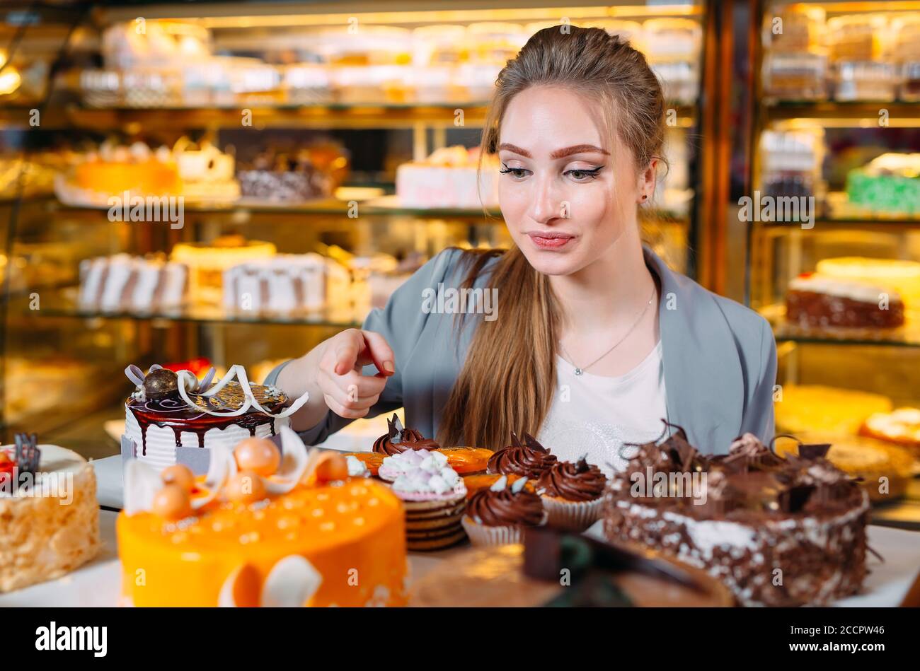 Girl looking at the bakery window with different pieces of cakes Stock ...