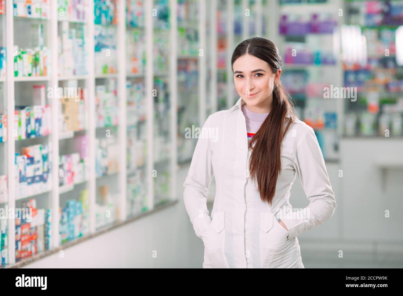 Pretty female pharmacist offering products of body care in pharmacy ...