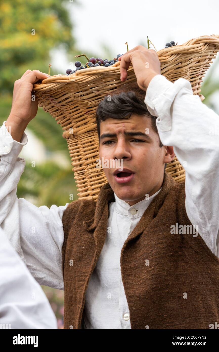FUNCHAL, MADEIRA, PORTUGAL - SEPTEMBER 4, 2016: Man carry the basket of ...