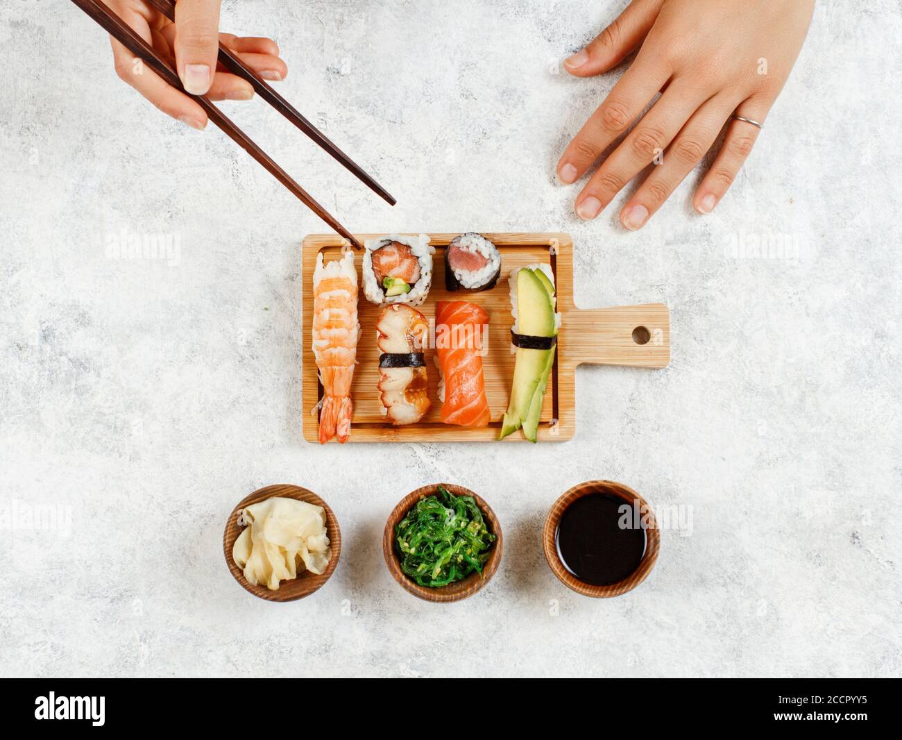 Top view of hand taking roll with chopsticks from a plate Stock Photo ...