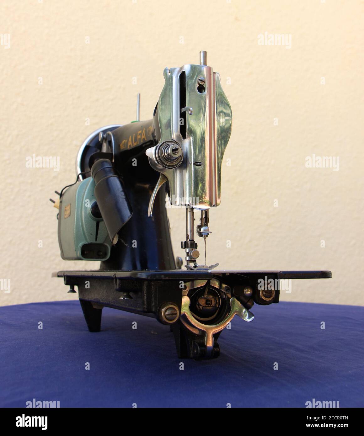 Old Alfa electric sewing machine black painted on a blue cloth ...