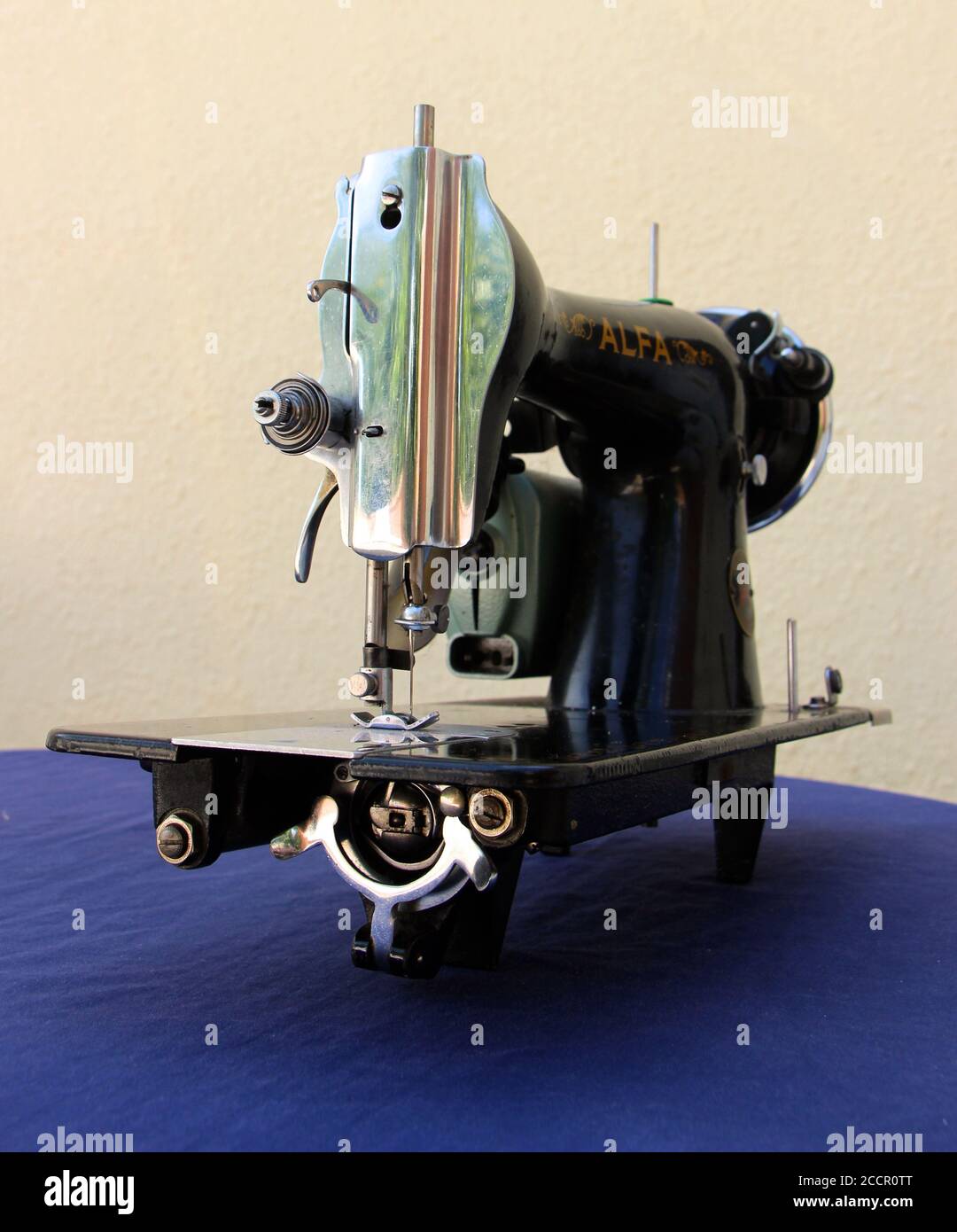 Old Alfa electric sewing machine black painted on a blue cloth ...