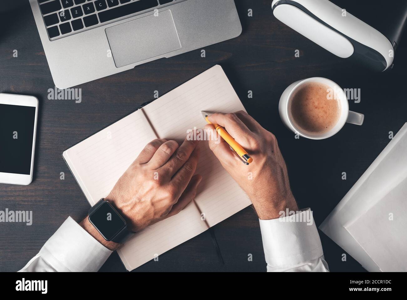 Top view of male business person writing notes or to do list in agenda ...