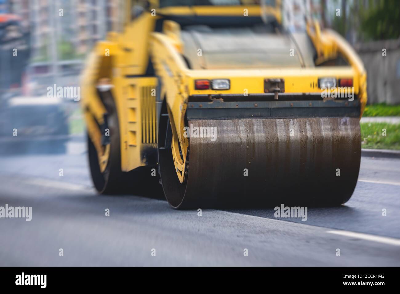 Asphalt paver machine and steam road roller during road construction ...