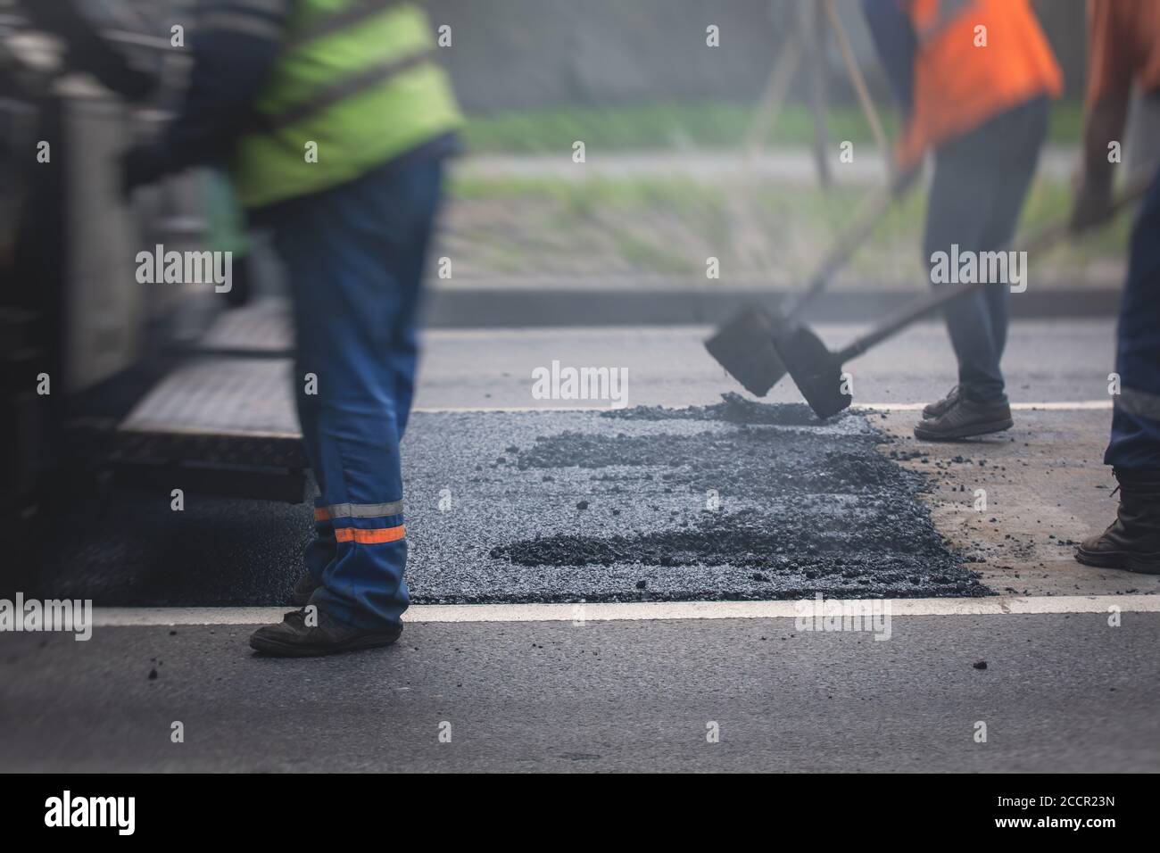 Asphalt paver machine and steam road roller during road construction ...