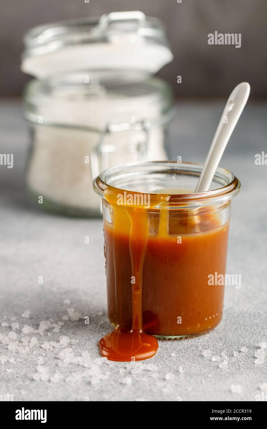 Homemade salted caramel in a glass jar. Delicious sauce with sea salt ...