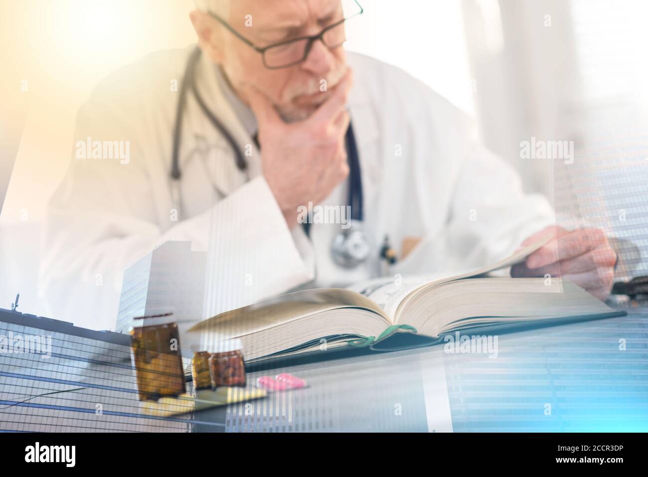 Senior doctor reading a textbook in medical office; multiple exposure ...