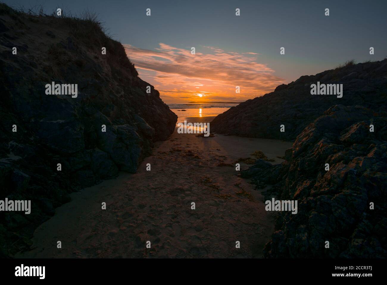 Sunset on the beach between hills Stock Photo - Alamy