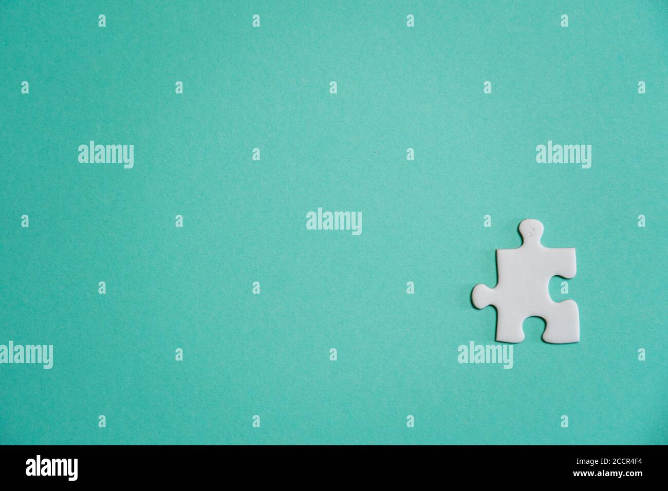 Fragment of a folded white jigsaw puzzle and a pile of uncombed puzzle ...
