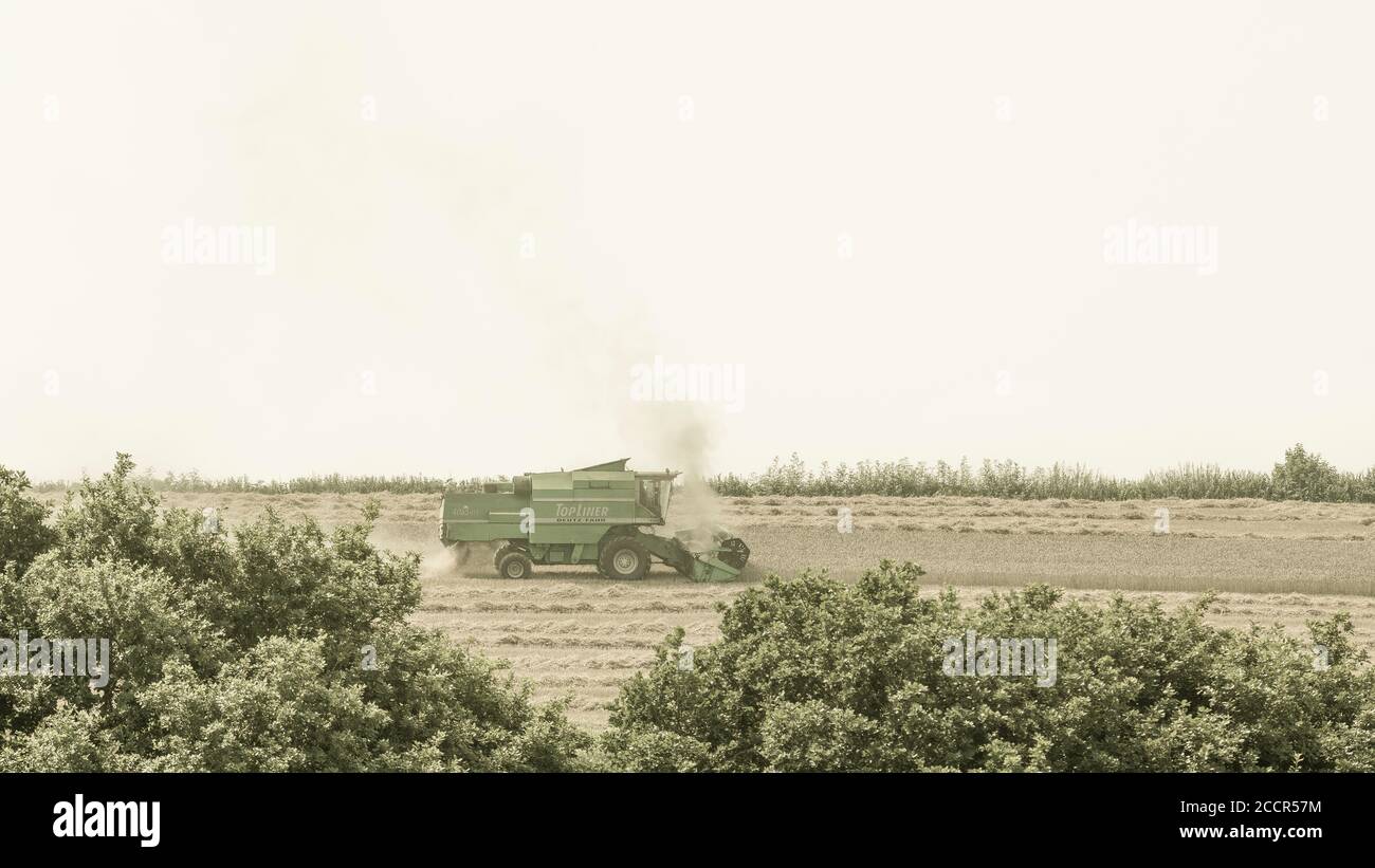Manipulated stylized image of Deutz-Fahr combine harvester on hill ...