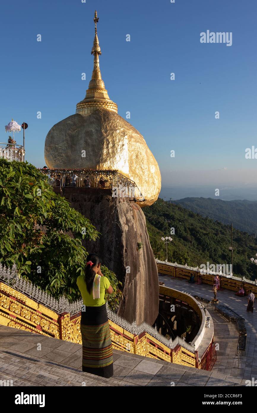 Burmese woman praying in front of Kyaiktiyo Pagoda - Golden rock. She ...