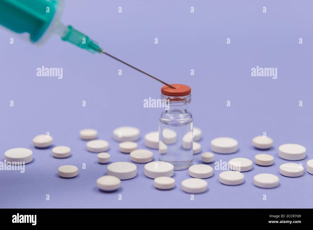 Pill and injection bottle on a purple background Stock Photo - Alamy