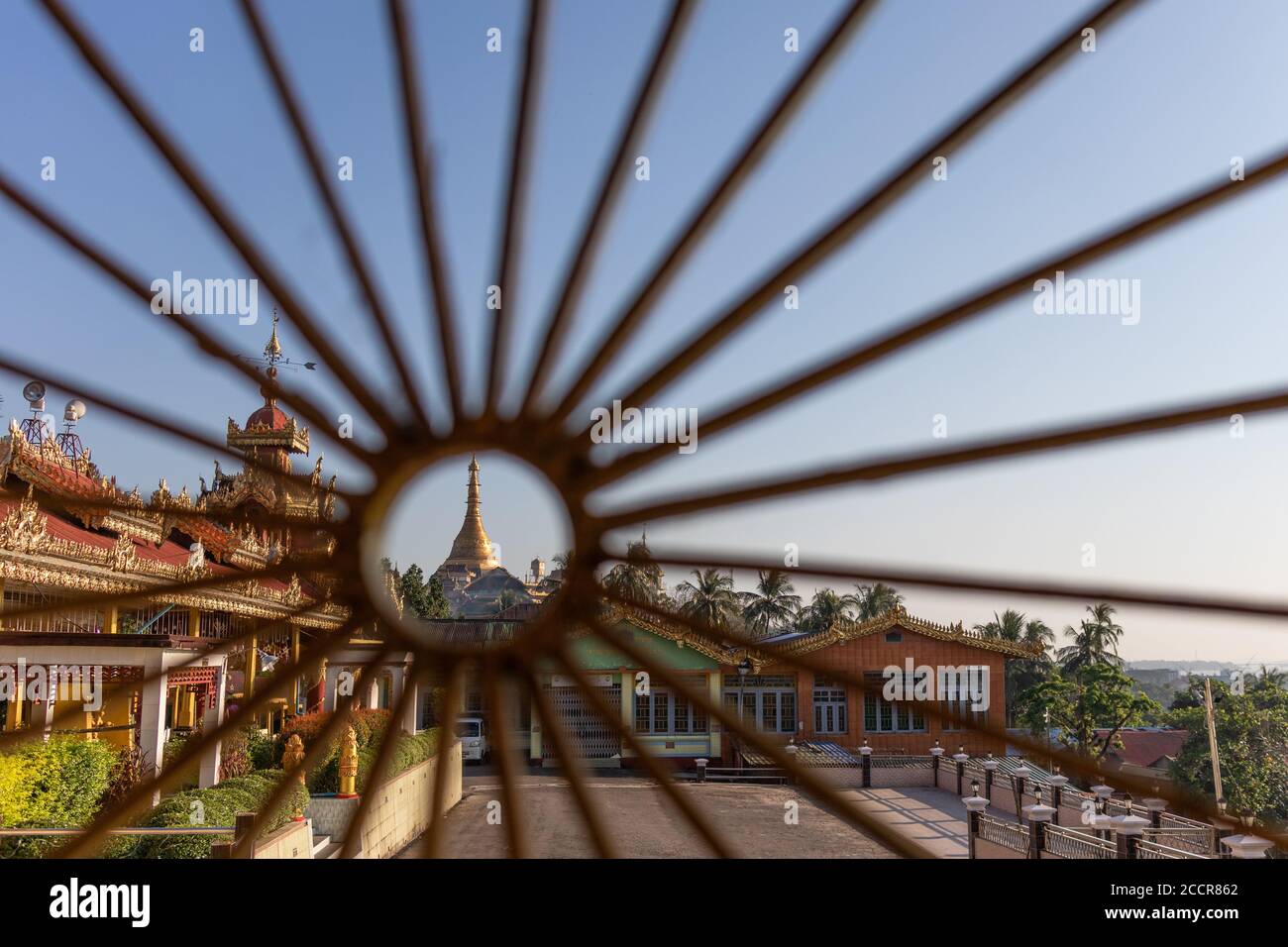 Golden pagoda framed inside a circle from behind a window. It looks ...