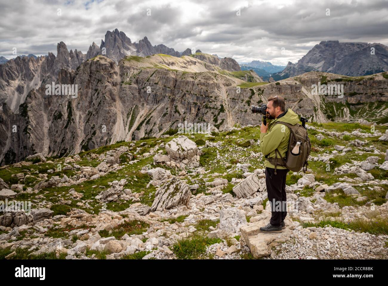 Photographer shoots mountain scene with his camera. Man with trekking ...