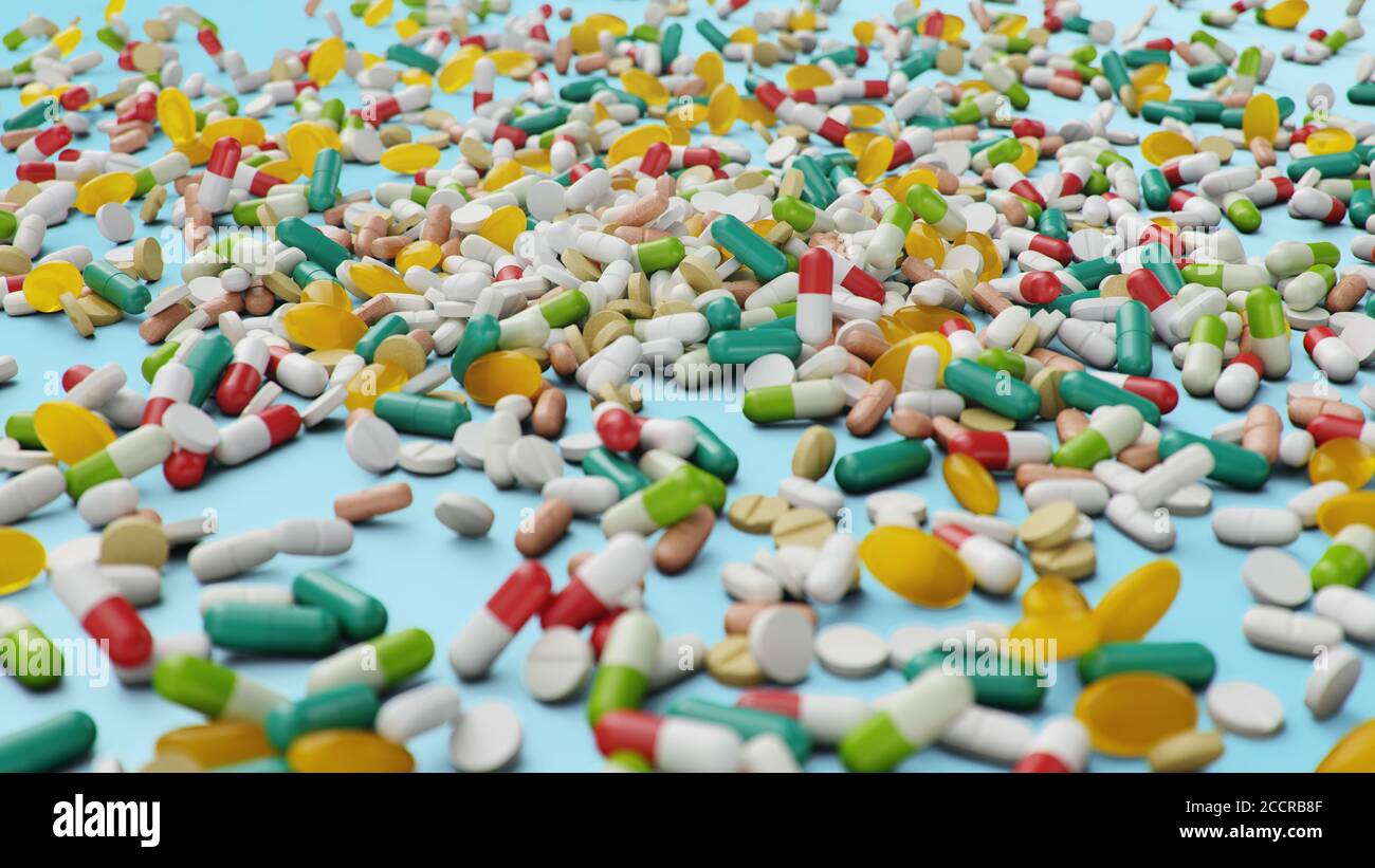 Many different colored tablets, capsules on blue background. Health ...