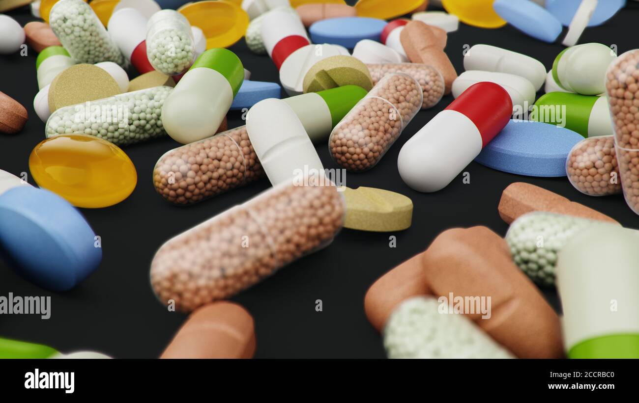 Many different colored tablets, capsules on black background. Health ...