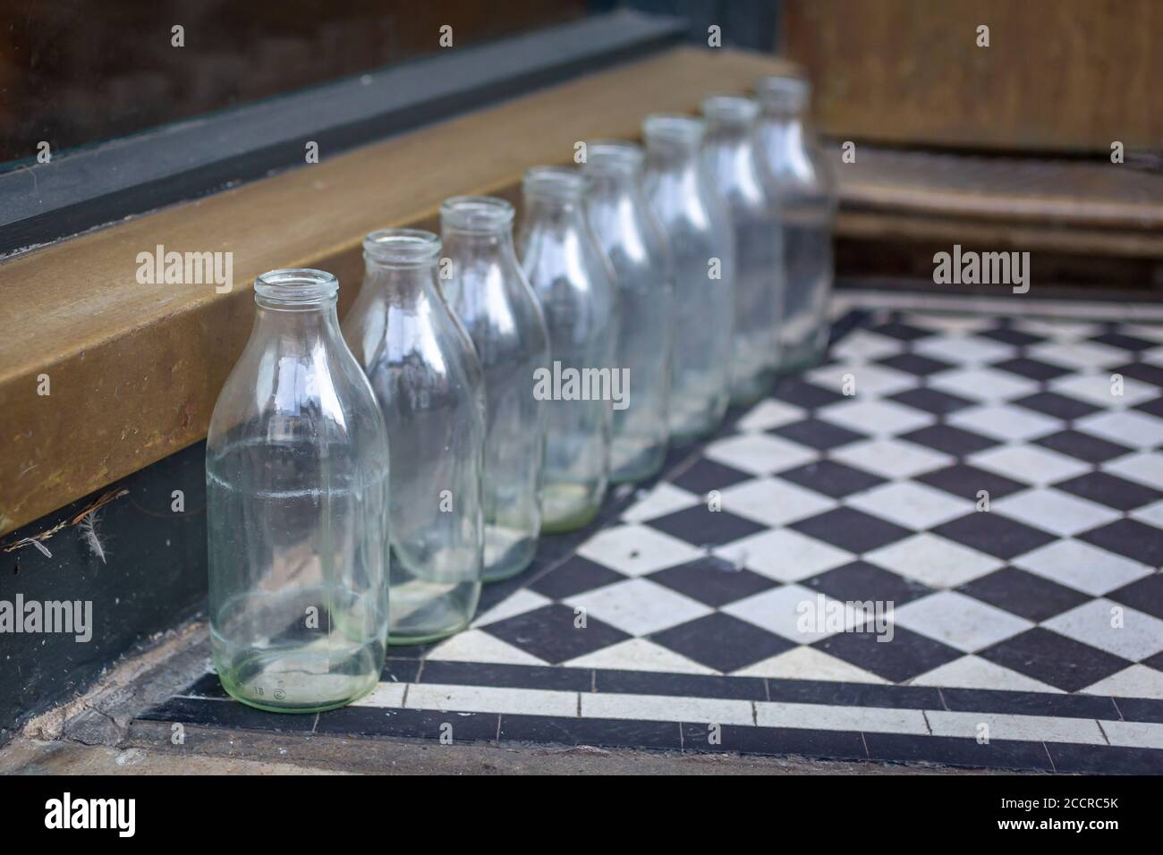 Empty milk bottles on a doorstep awaiting collection Stock Photo - Alamy