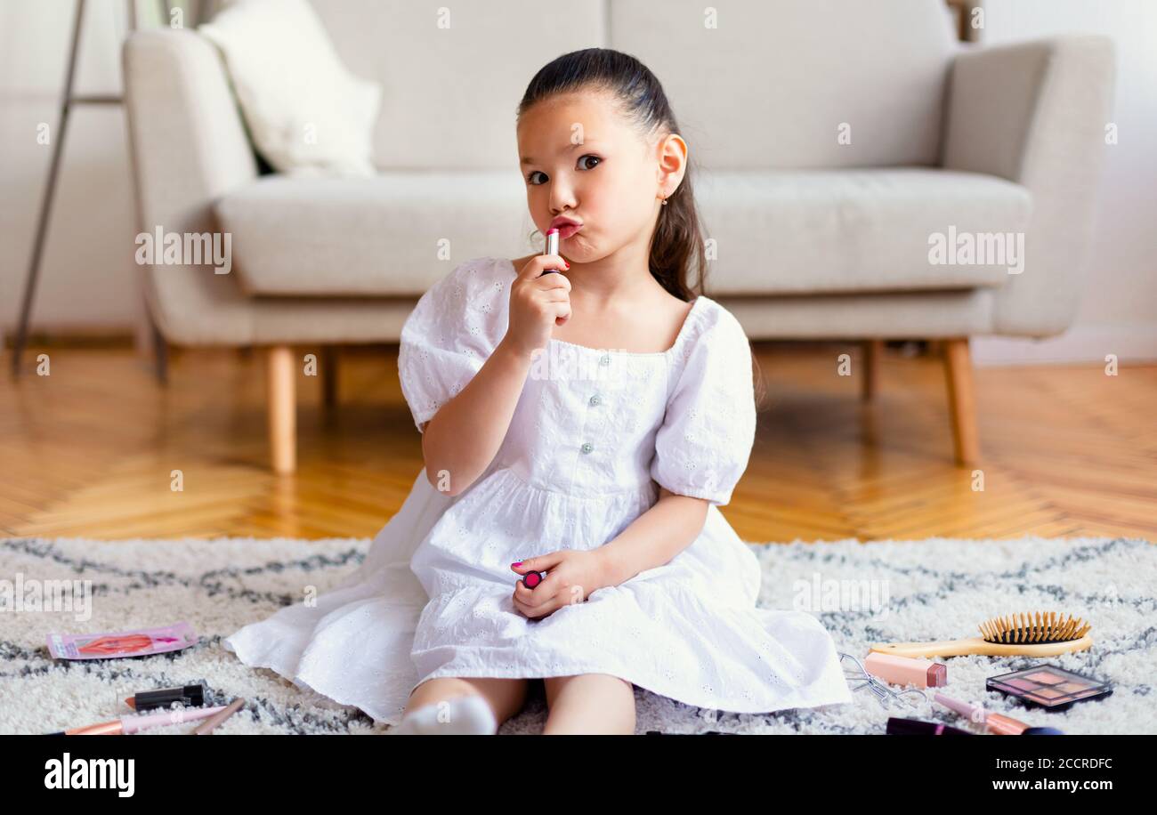 Little Girl Putting On Lipstick Playing With Mother's Cosmetics Indoor ...