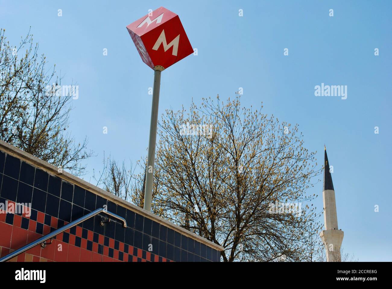 Low angle view of Ankara metro sign with trees and minaret background ...