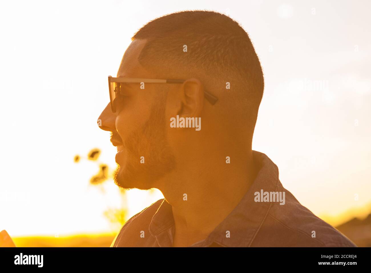 Happy latin man walking and enjoying the sunset with a natural ...