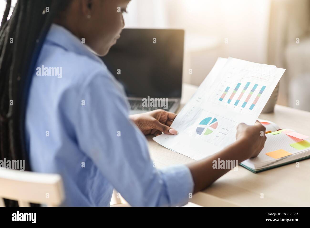 Concentrated black businesswoman checking financial reports, economic ...
