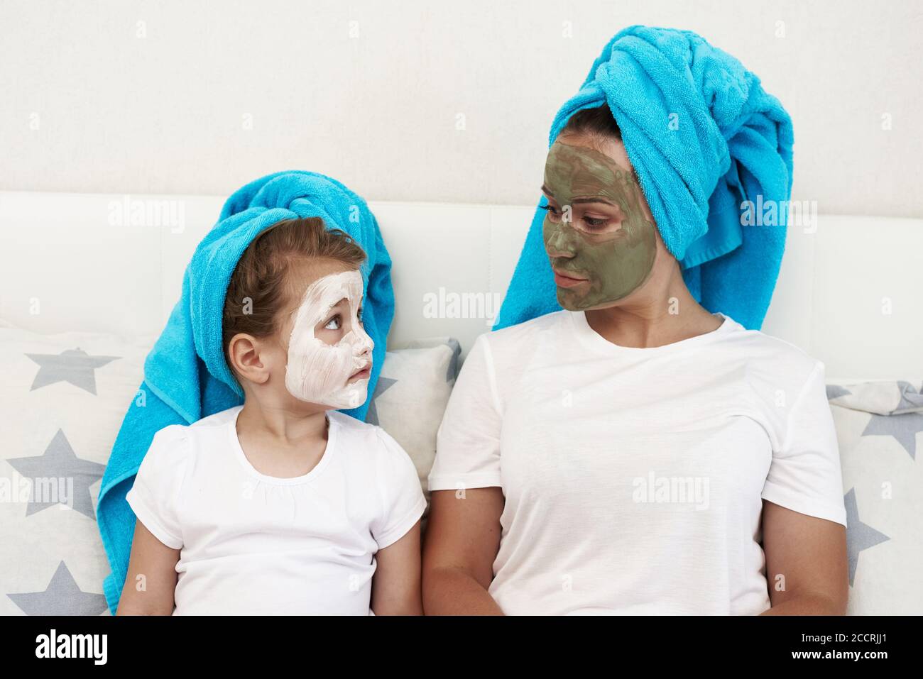 Mom with her daughter making clay face mask. Mother with child doing ...