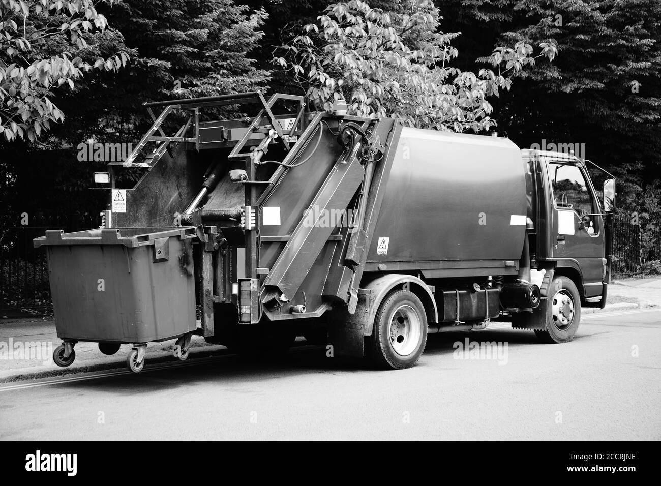 Black and white monochrome image green garbage truck vehicle with an ...