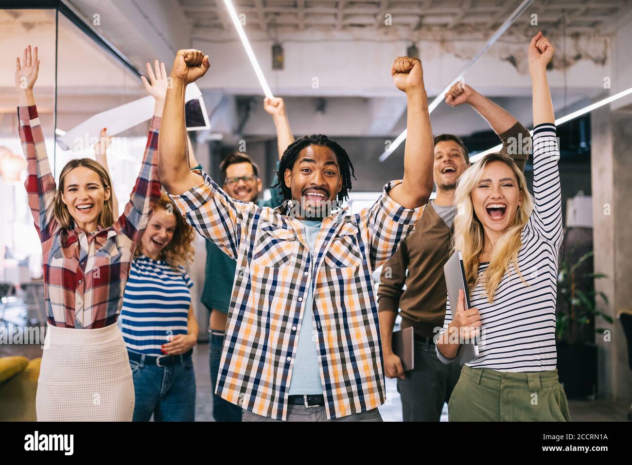Happy business people celebrating success at company Stock Photo - Alamy