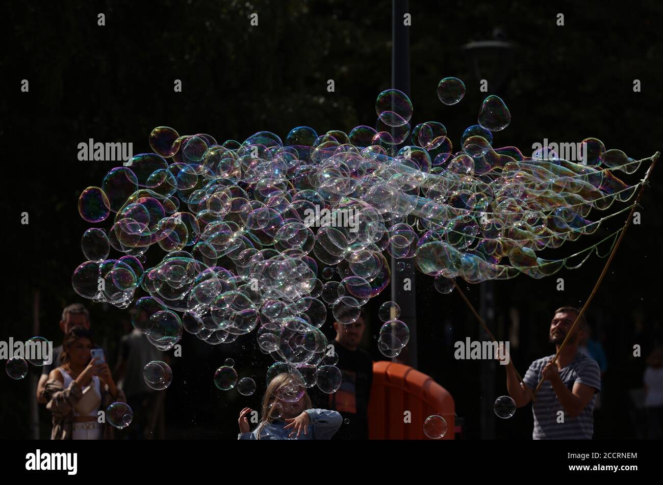 A child is entertained by a bubble-blowing performer at Bankside in ...