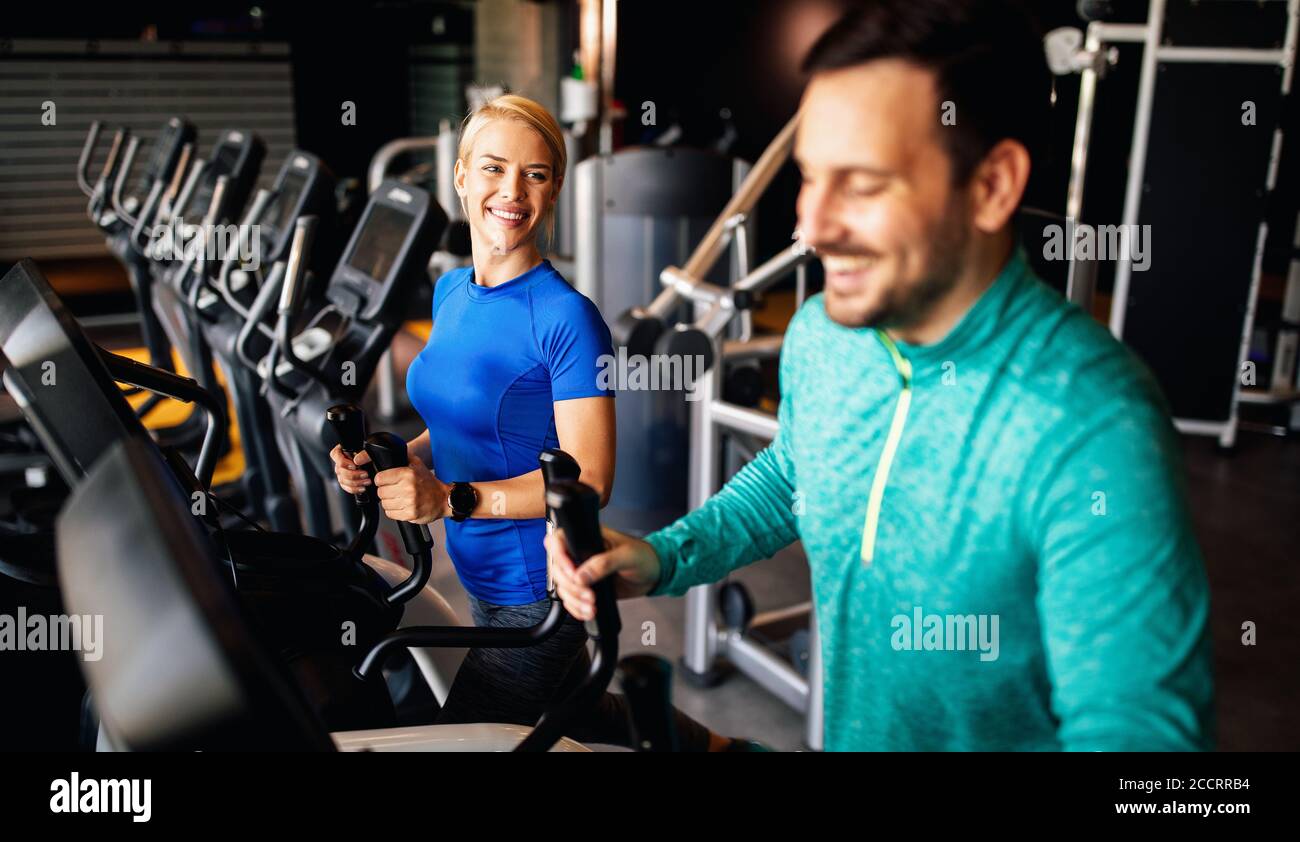 Fit happy man exercising at the gym on a machine Stock Photo - Alamy