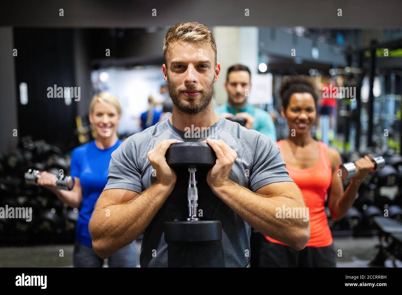 Group of young friends people doing exercises in gym Stock Photo - Alamy
