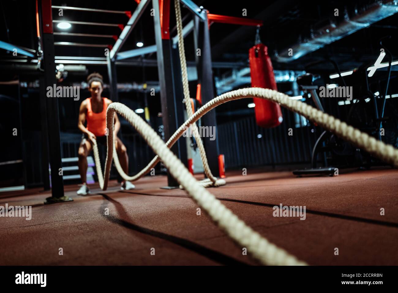 Happy fit woman working out with battle ropes at a gym Stock Photo - Alamy