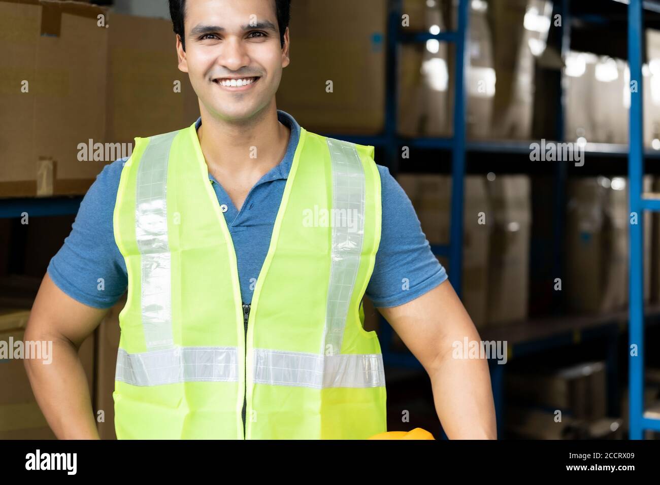 Portrait of Indian asian warehouse worker with safety vest stand and ...