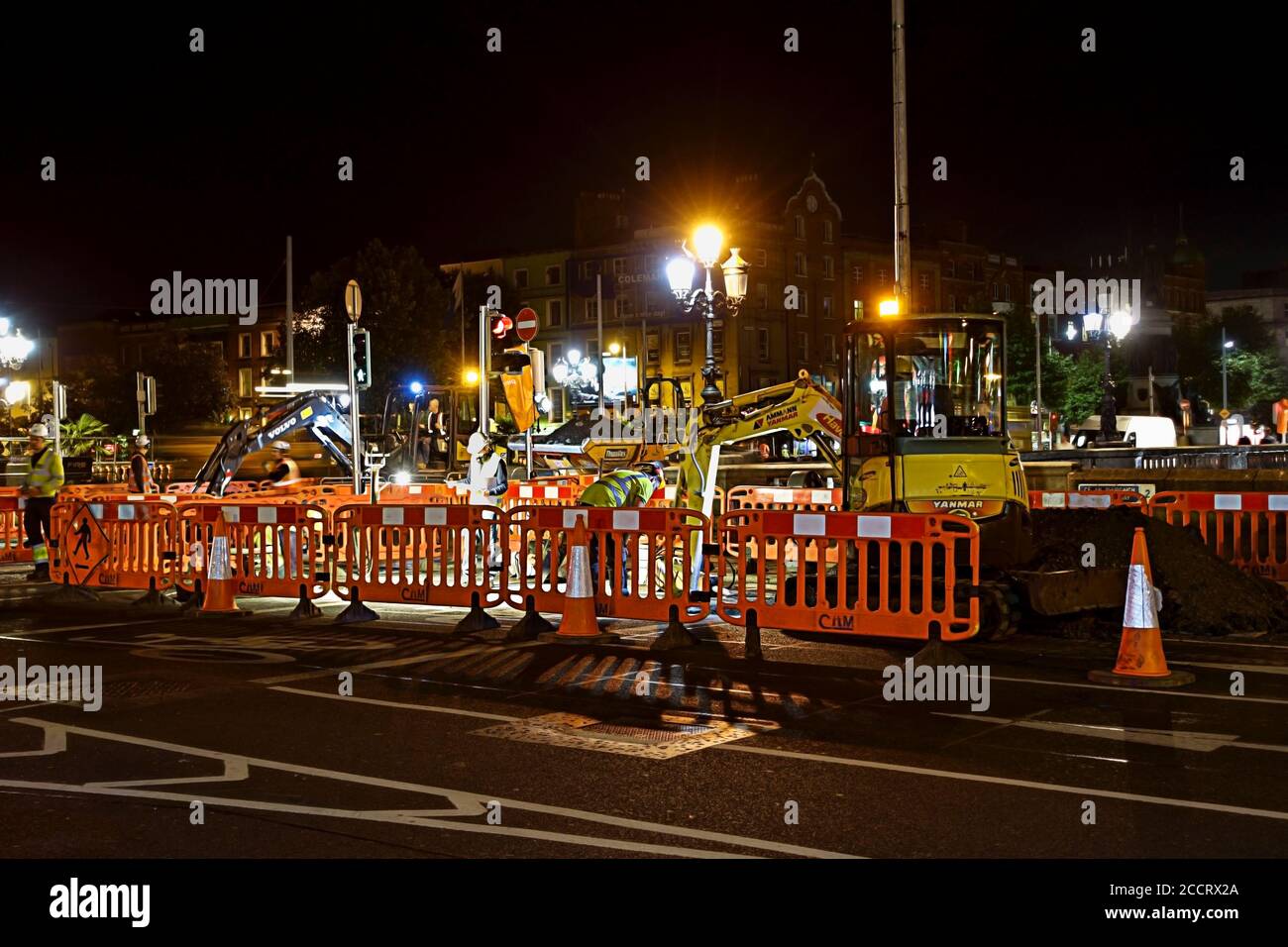 Road work team crew working at night. Machinery on construction site ...