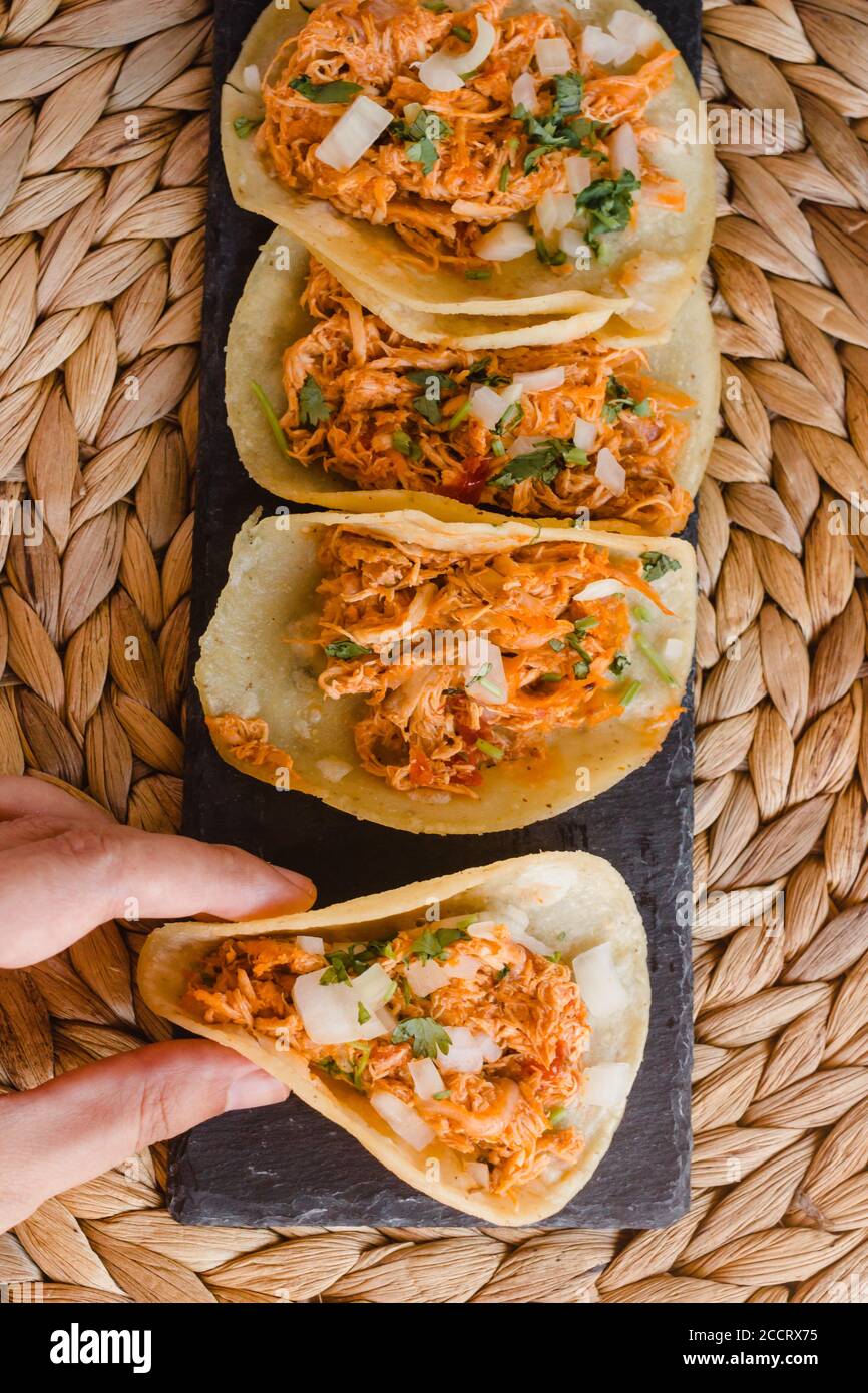 Mexican tacos on a row and a hand holding one Stock Photo - Alamy