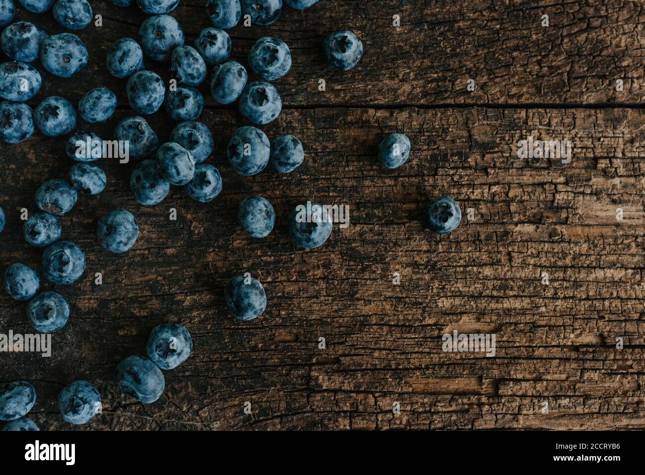 Blue fresh blueberries are scattered on an wooden table Stock Photo - Alamy