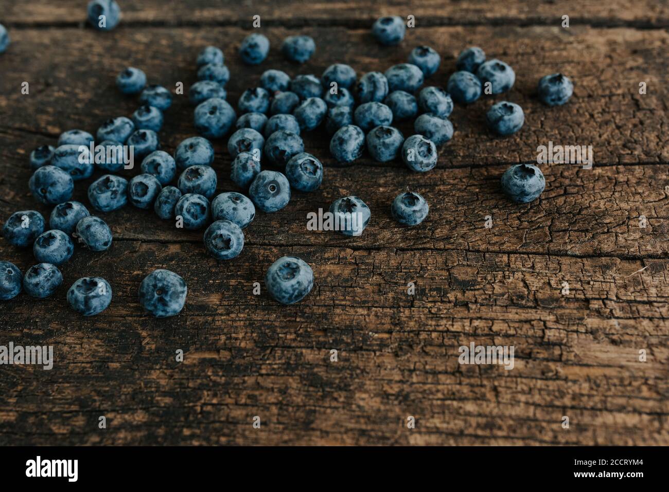 Blue fresh blueberries are scattered on an wooden table Stock Photo - Alamy