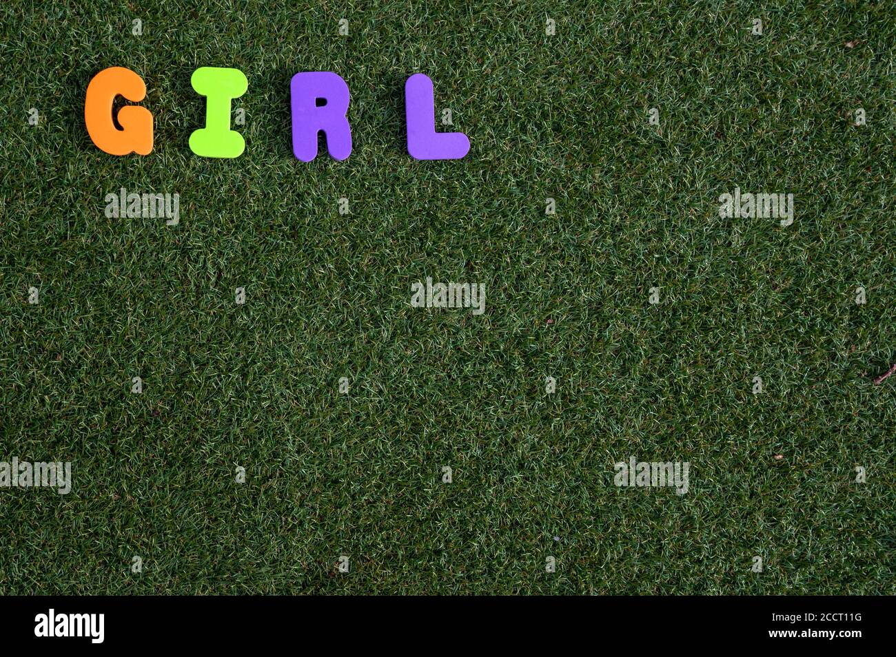 Girl spelt out on green grass background with colourful letters Stock ...