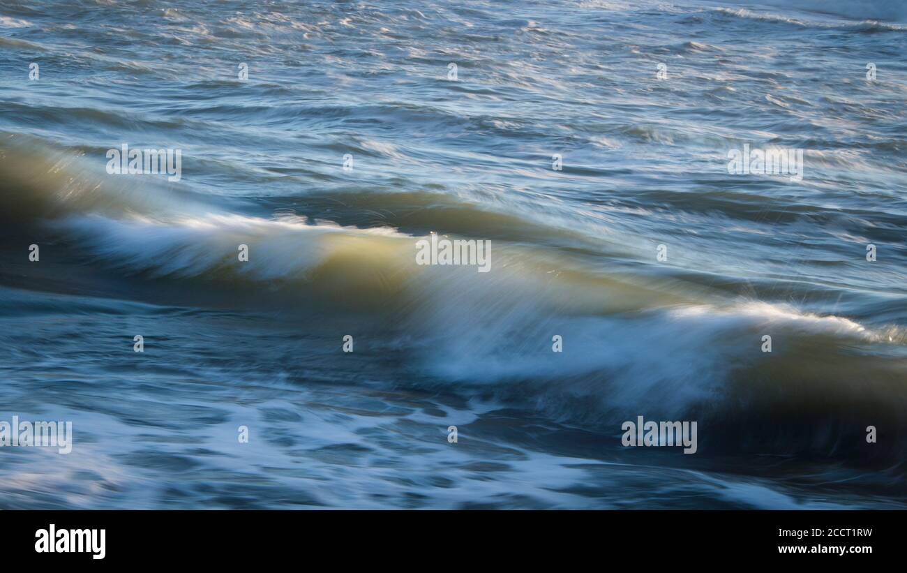 Image of crashing waves at sunset using a slow shutter speed Stock ...