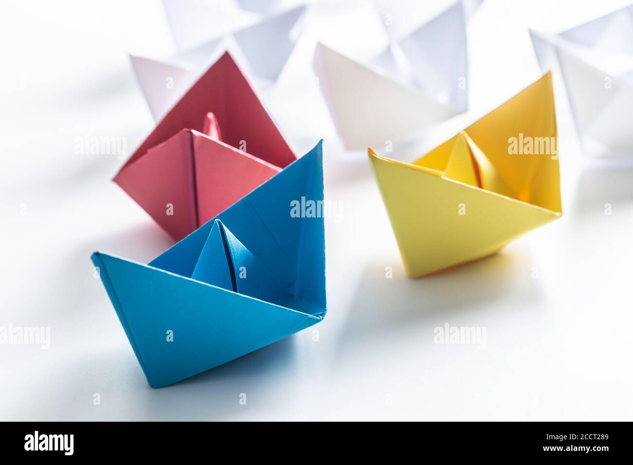 Multi colored paper boats. Concept of leadership boats for teamwork ...