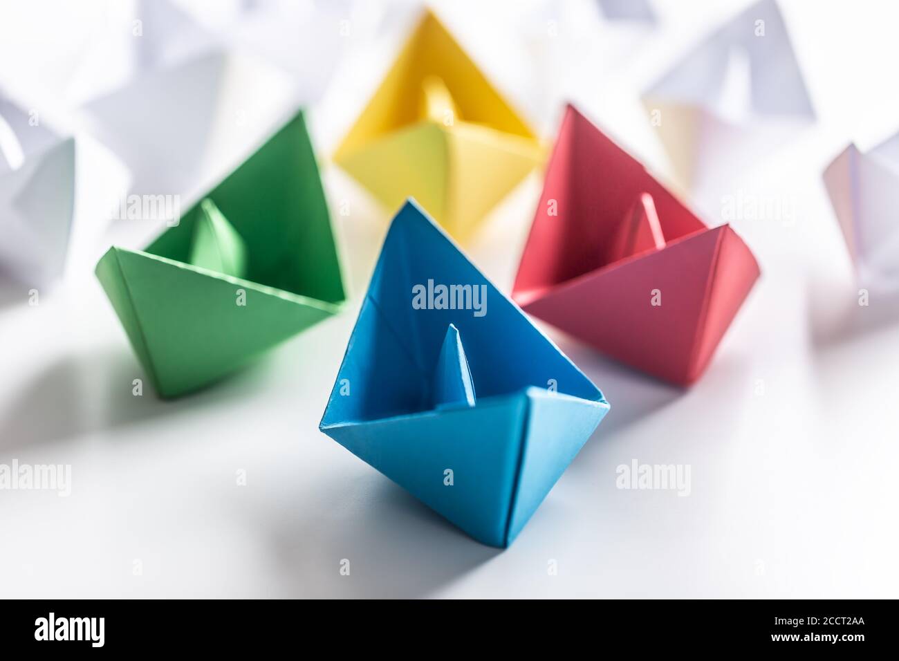 Multi colored paper boats. Concept of leadership boats for teamwork ...
