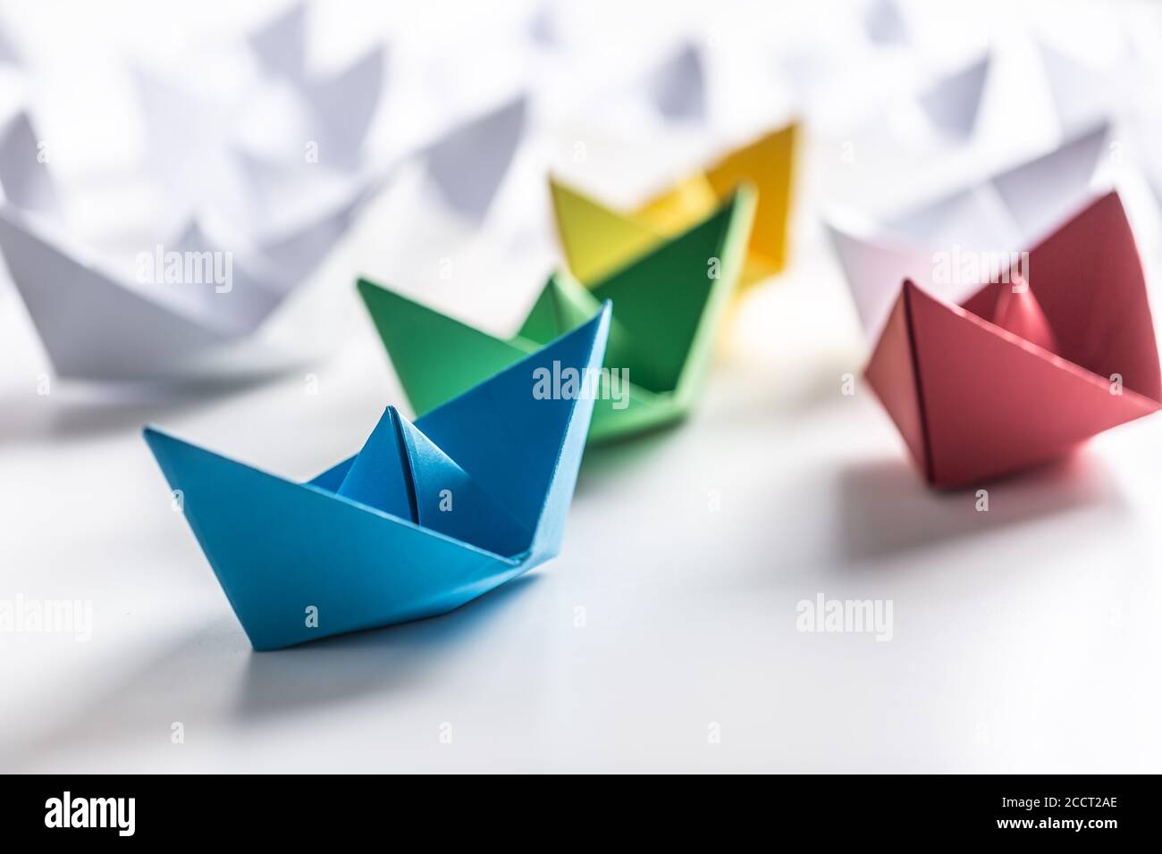 Multi colored paper boats. Concept of leadership boats for teamwork ...