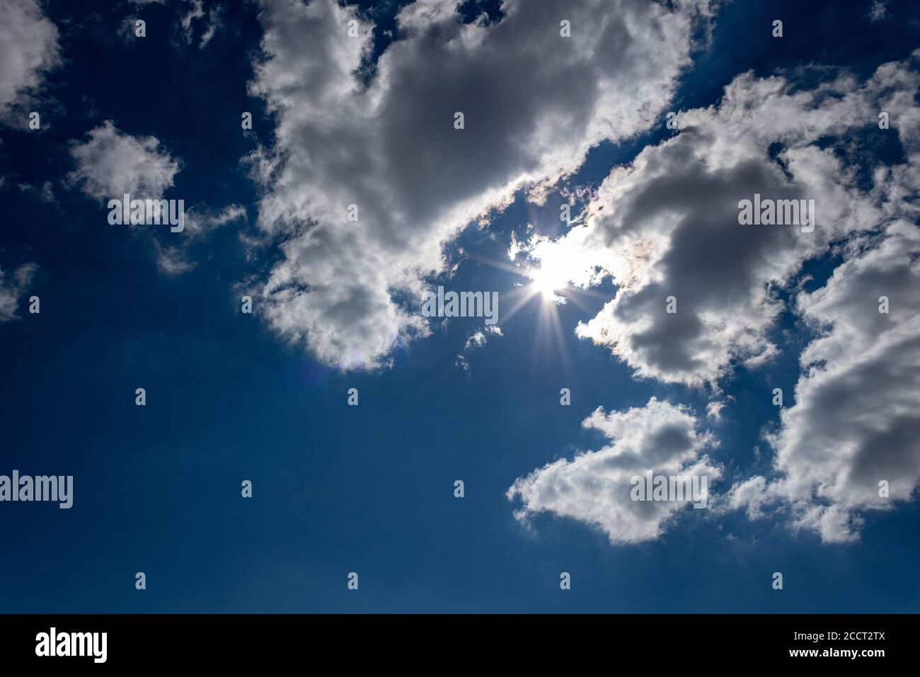 Worm's eye view of the sun behind thick clouds with sun beams Stock ...