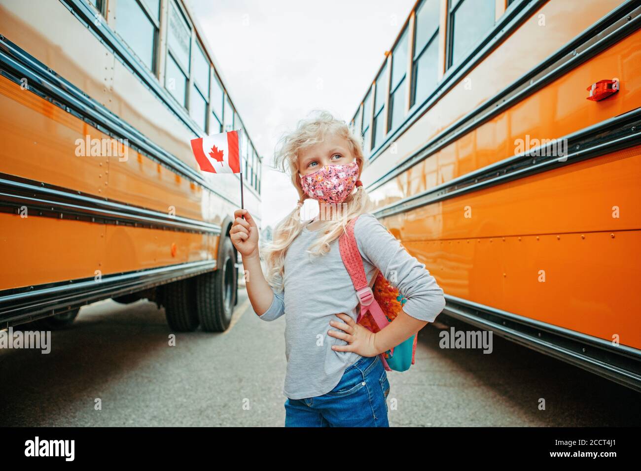 Caucasian girl student with face mask holding Canadian flag. Student ...