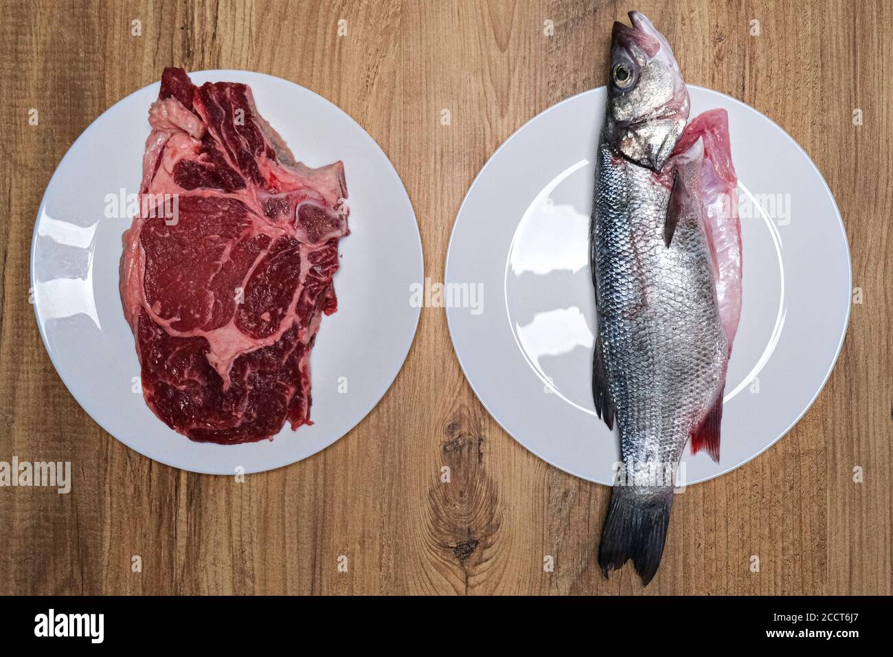 Raw beef steak and and fresh fish on white plates Top view. protein ...