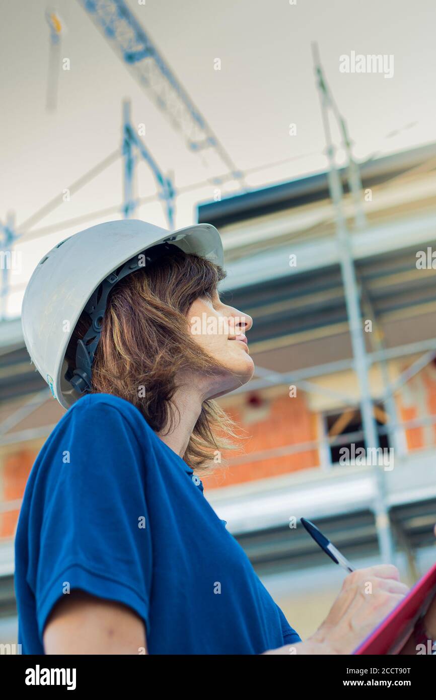 Woman, female engineer, caucasian, age 40, wearing a safety white cap ...