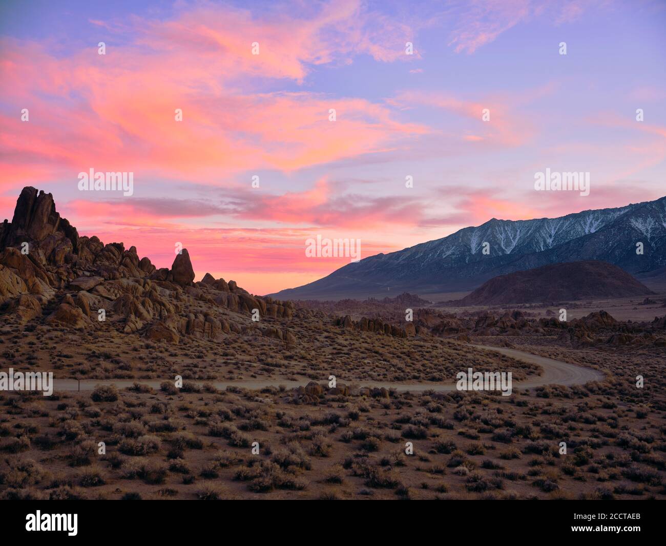 Sunset behind rock formations in an arid desert landscape Stock Photo ...