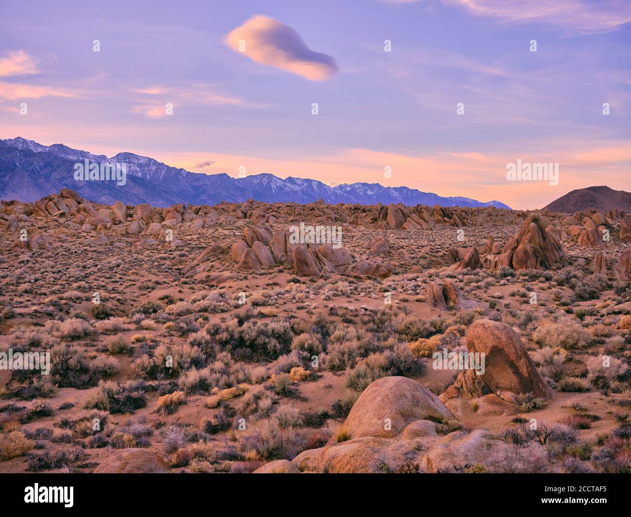 A fluffy cloud floats above an empty desert landscape, Alabama Hills ...
