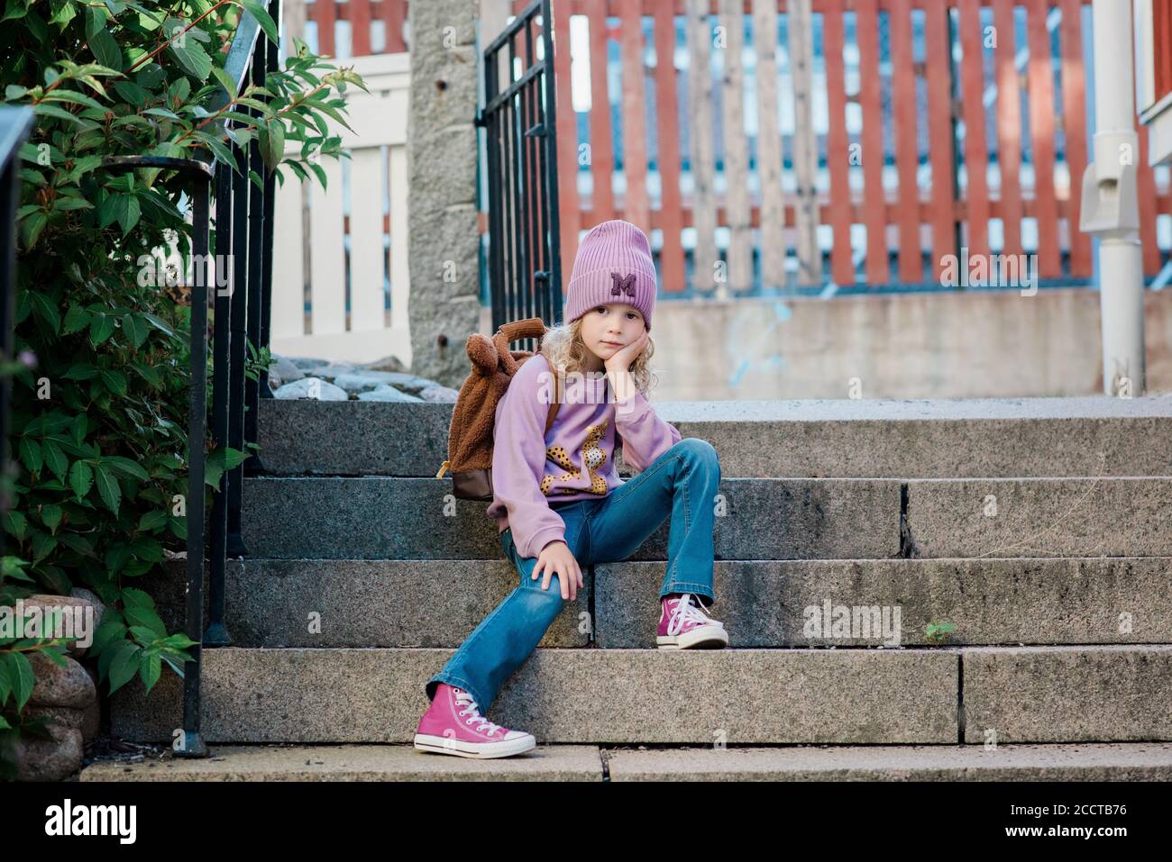 portrait of a young girl sat waiting for school Stock Photo - Alamy