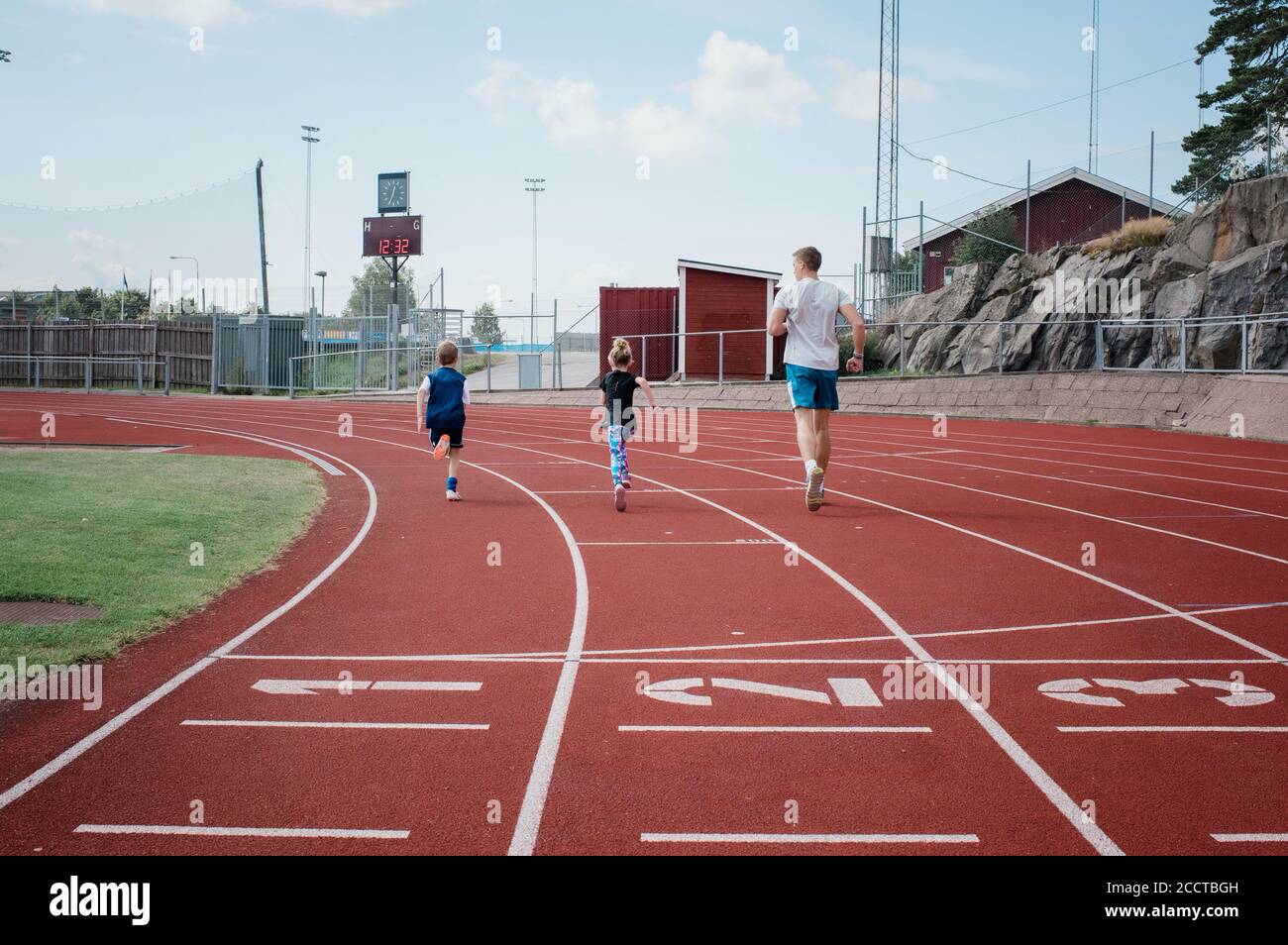 father running with his kids on a race track Stock Photo - Alamy